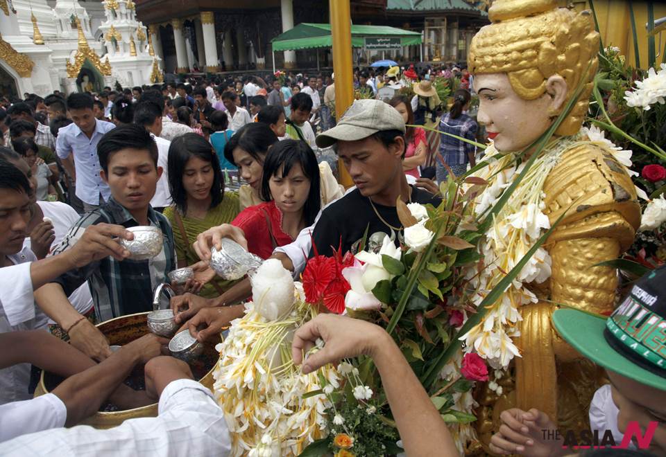 Myanmarese devotees pour water on Buddha statue to celebrate Full Moon ...